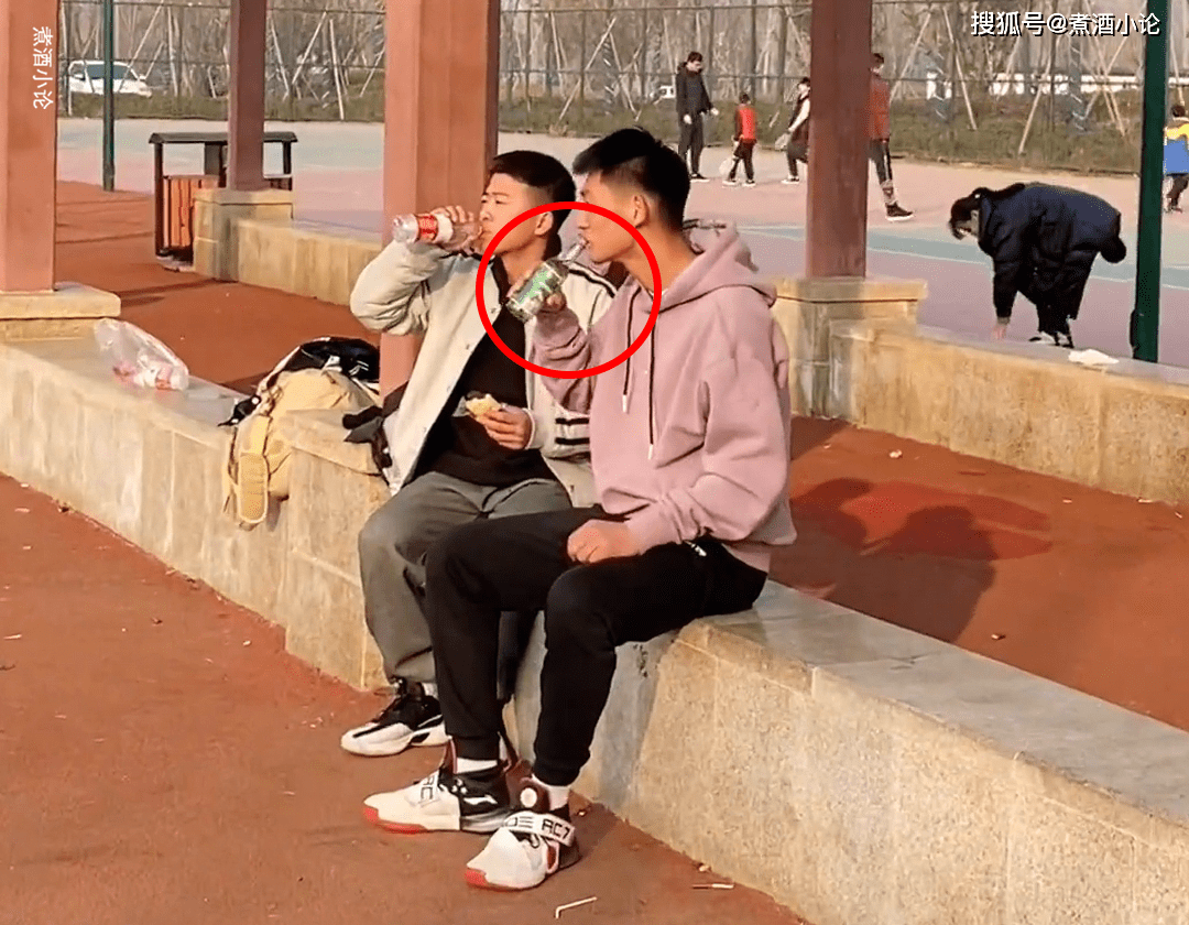 小伙打球前坐场边喝白酒热身，“天气太冷，喝一点上场不那么冷”_运动_篮球场_包里